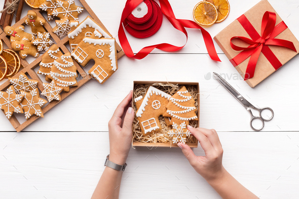 Woman packaging Christmas gingerbread cookies into gift box Stock Photo ...
