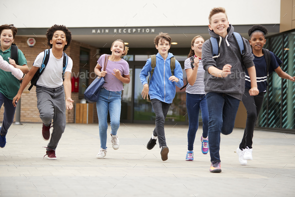 Group Of High School Students Running Out Of School Buildings Towards ...