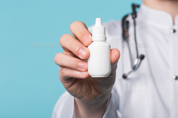 Medical drops in doctor's hand on blue background Stock Photo by Satura_