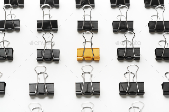 Golden binder clip standing between black ones Stock Photo by Prostock ...
