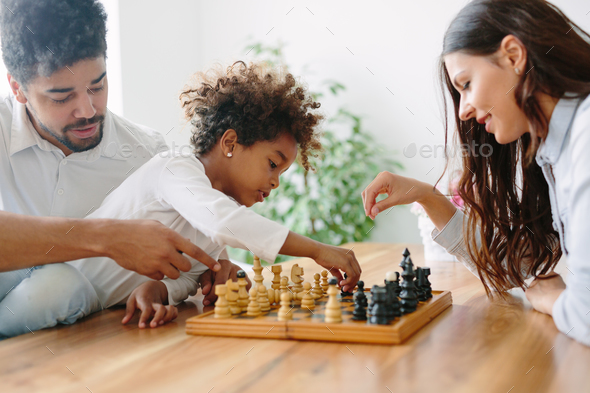 Happy family playing chess together at home Stock Photo by nd3000 ...