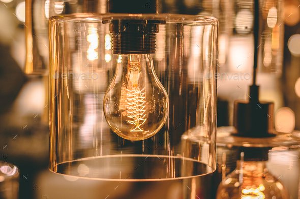 Close up view on a transparent modern lamp with a retro bulb inside it ...
