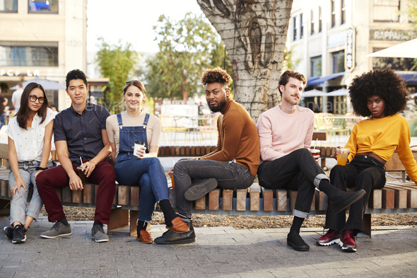 Six millennial hipster friends in the city relaxing by a fountain with ...