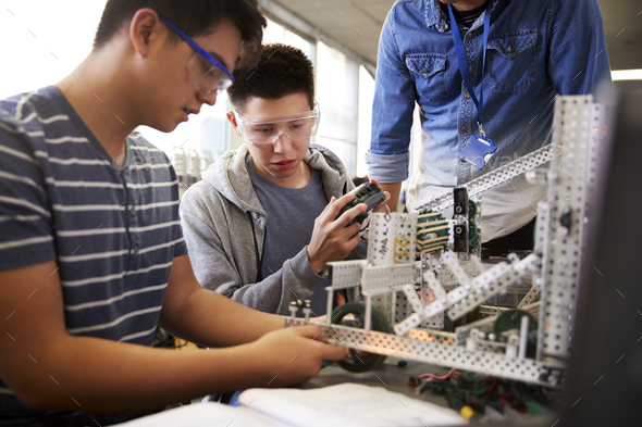 Teacher With Two Male College Students Building Machine In Science ...