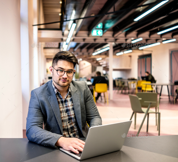 Young man in coworking space working on his laptop Stock Photo by viki2win