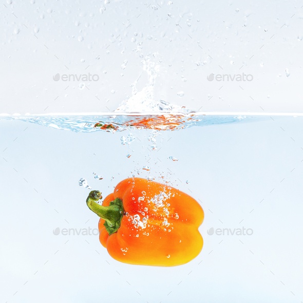 Colored orange paprika in water splashes on blue background Stock Photo ...