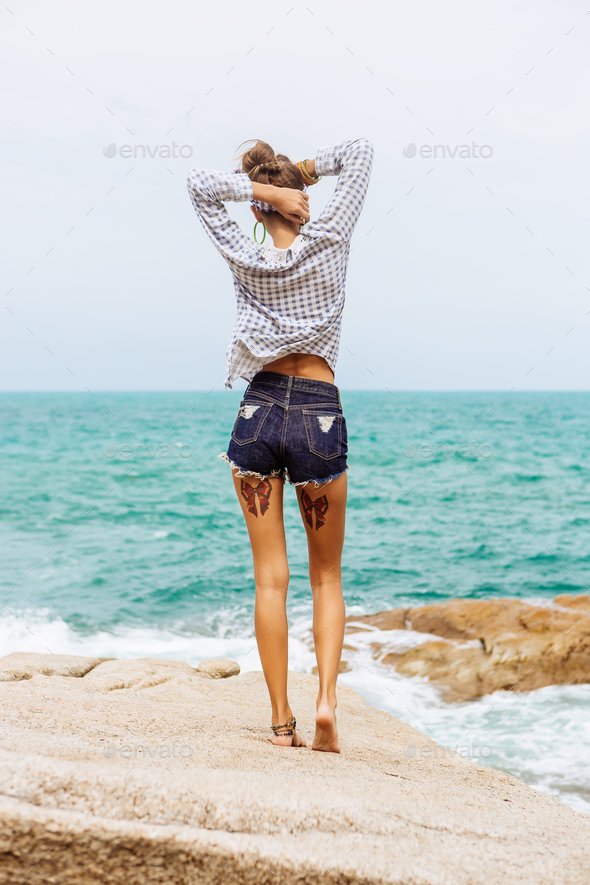 Pretty girl on big stone at the beach. Stock Photo by nikkolia | PhotoDune