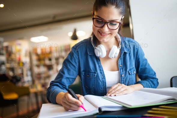 College woman studying at the library looking happy Stock Photo by nd3000