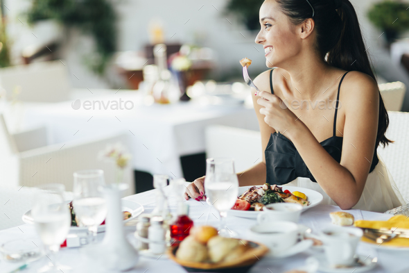 Attractive woman eating in restaurant Stock Photo by nd3000 | PhotoDune
