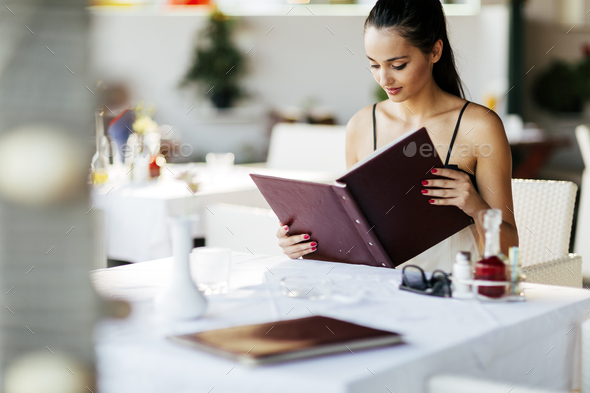 Beautiful woman ordering from menu Stock Photo by nd3000 | PhotoDune