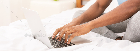 African-american programmer typing on laptop in bed Stock Photo by ...