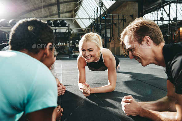 Gym friends smiling and planking together during a workout class Stock ...