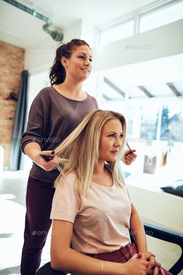 Smiling young woman getting her hair done at a salon Stock Photo by ...
