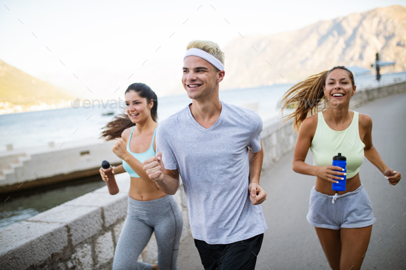 Outdoor portrait of group of friends running and jogging in nature ...