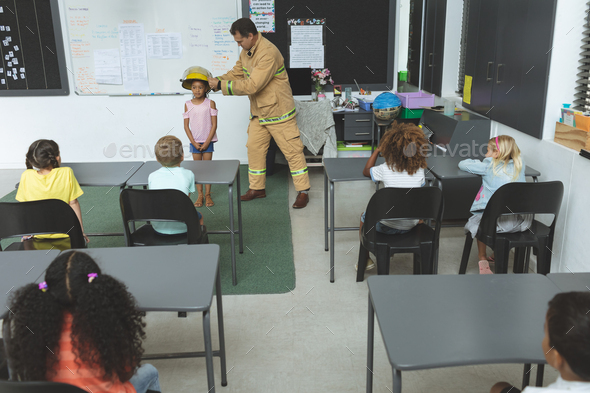 Overhead view of firefighter teaching student about fire safety in ...