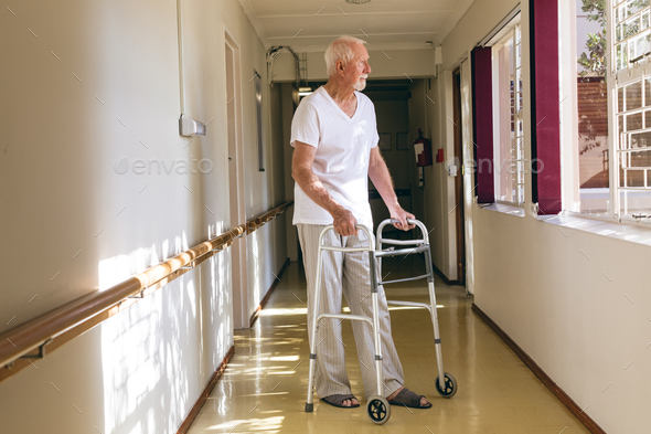 Side view of senior Caucasian male patient standing with walker in ...