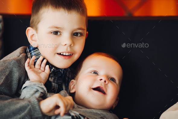Happy boy embracing his little little brother Stock Photo by StudioLucky
