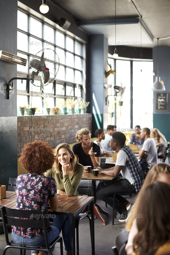 Interior Of Busy Coffee Shop With Customers Sitting At Tables Stock ...
