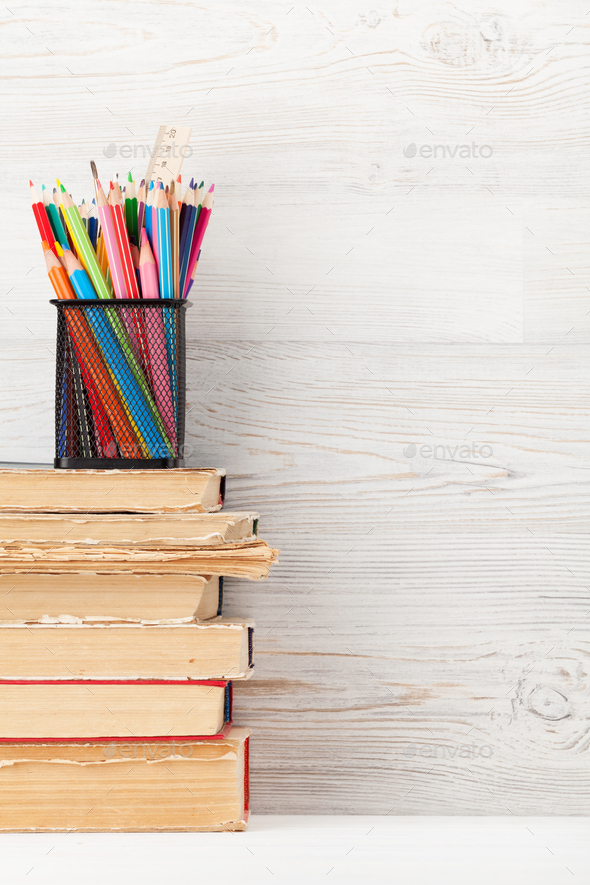 Home office workplace with stack of old books Stock Photo by karandaev