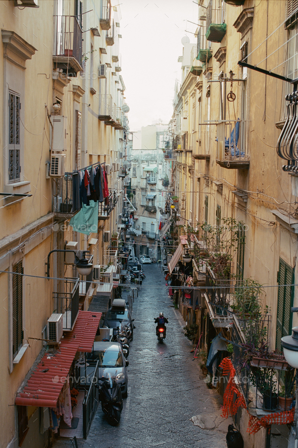 Alleyway with motorbike driving among old houses in Naples, Italy Stock ...