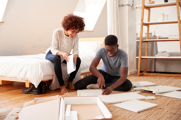 Couple In New Home Putting Together Self Assembly Furniture Stock Photo ...