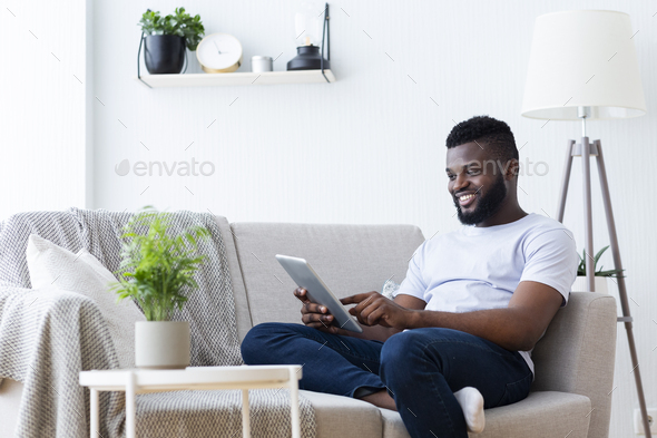 African-american man using digital tablet at home Stock Photo by ...