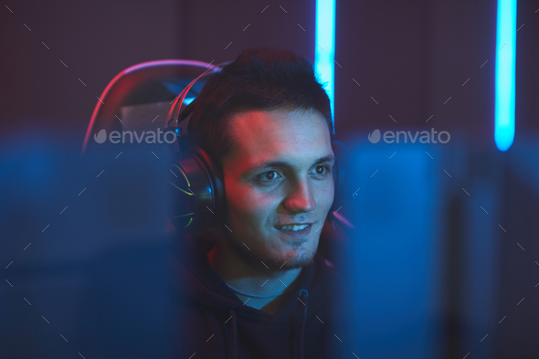 Excited gamer watching computer monitor Stock Photo by seventyfourimages