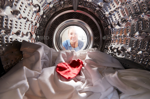 Woman Looking Inside Washing Machine With Red Sock Mixed With White ...