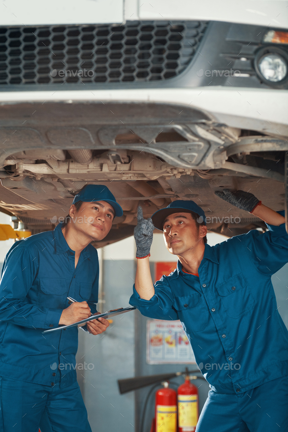 Mechanics inspecting car bottom Stock Photo by DragonImages | PhotoDune