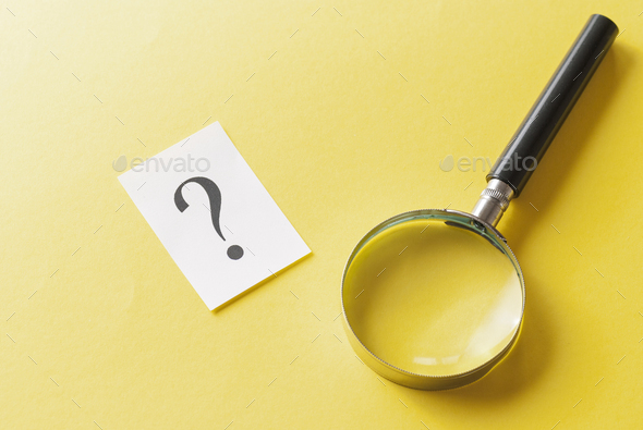 Magnifying glass with printed question mark Stock Photo by sergign