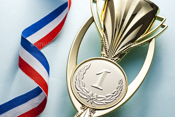 Gold first place winners medallion with ribbon Stock Photo by sergign
