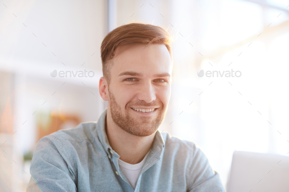Portrait of Smiling Man in Office Stock Photo by seventyfourimages