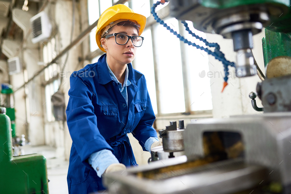 Female Machine Operator at Modern Plant Stock Photo by seventyfourimages
