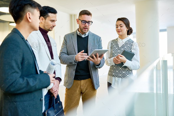 Modern Business People Chatting in Office Stock Photo by seventyfourimages