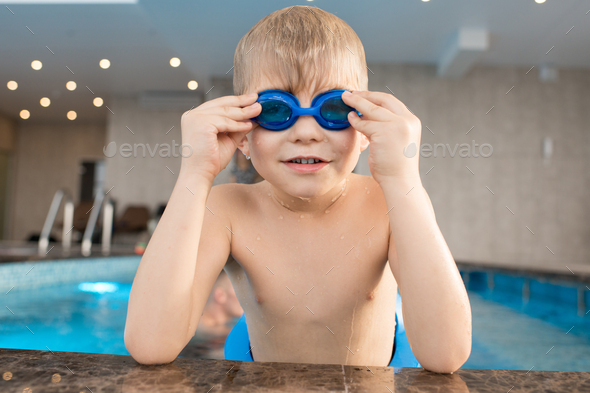 Wet kid getting out of swimming pool Stock Photo by seventyfourimages