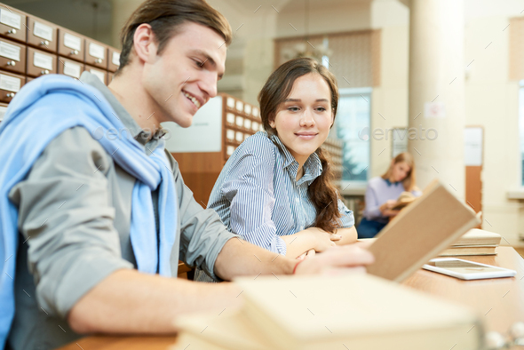 Cheerful students learning new material in library Stock Photo by ...