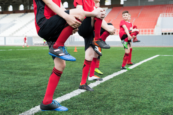 Football Team Stretching in Field Stock Photo by seventyfourimages