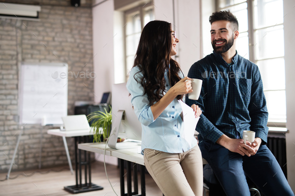 Coworking colleagues having conversation at workplace Stock Photo by nd3000