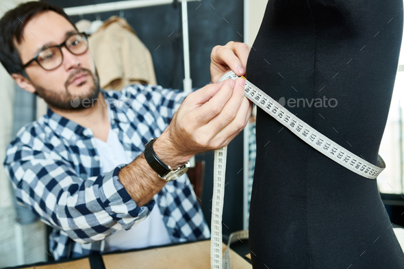 Man designing dress with mannequin Stock Photo by seventyfourimages