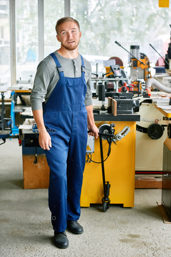 Workman Posing Next to Machine Units Stock Photo by seventyfourimages