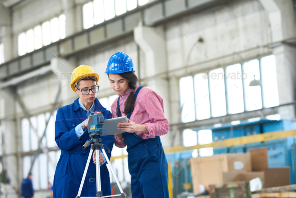 Female builders examining measurements Stock Photo by seventyfourimages