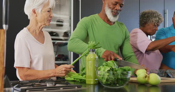 Happy senior diverse people cooking in kitchen at retirement home ...