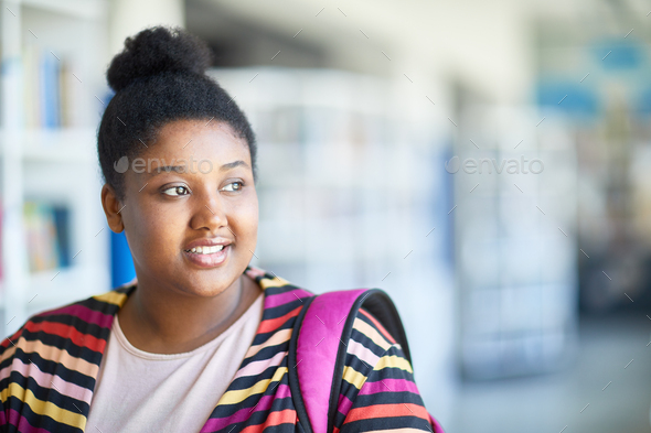 Smiling African student reflecting about future Stock Photo by Pressmaster