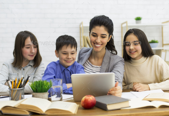 School kids watching videos with teacher on tablet Stock Photo by ...