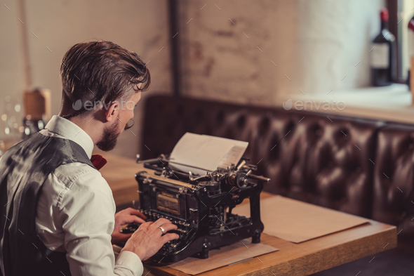 Working man typing on a retro typewriter Stock Photo by AboutImages
