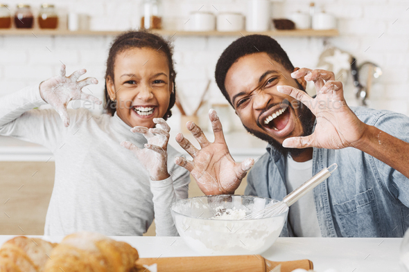 Happy father and daughter with funny growling faces in kitchen Stock ...