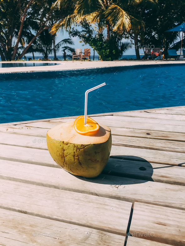 Fresh coconut by the swimming pool Stock Photo by davidpradoperucha