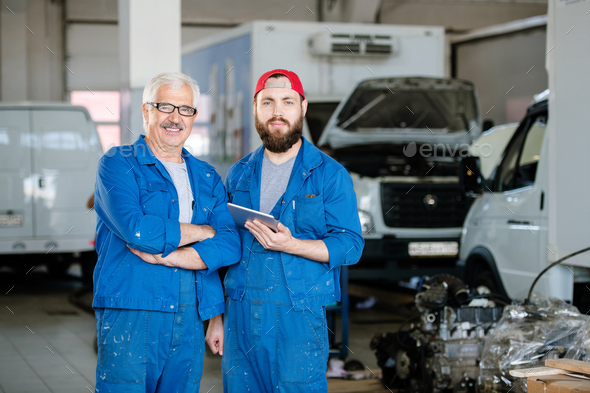 Successful young and mature workers of machine repair service in ...