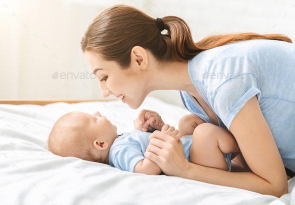 Mom admiring her newborn baby, looking at him with love Stock Photo by ...