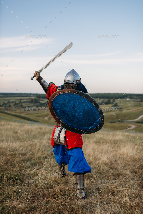 Medieval knight with sword poses in armor, fighter Stock Photo by ...